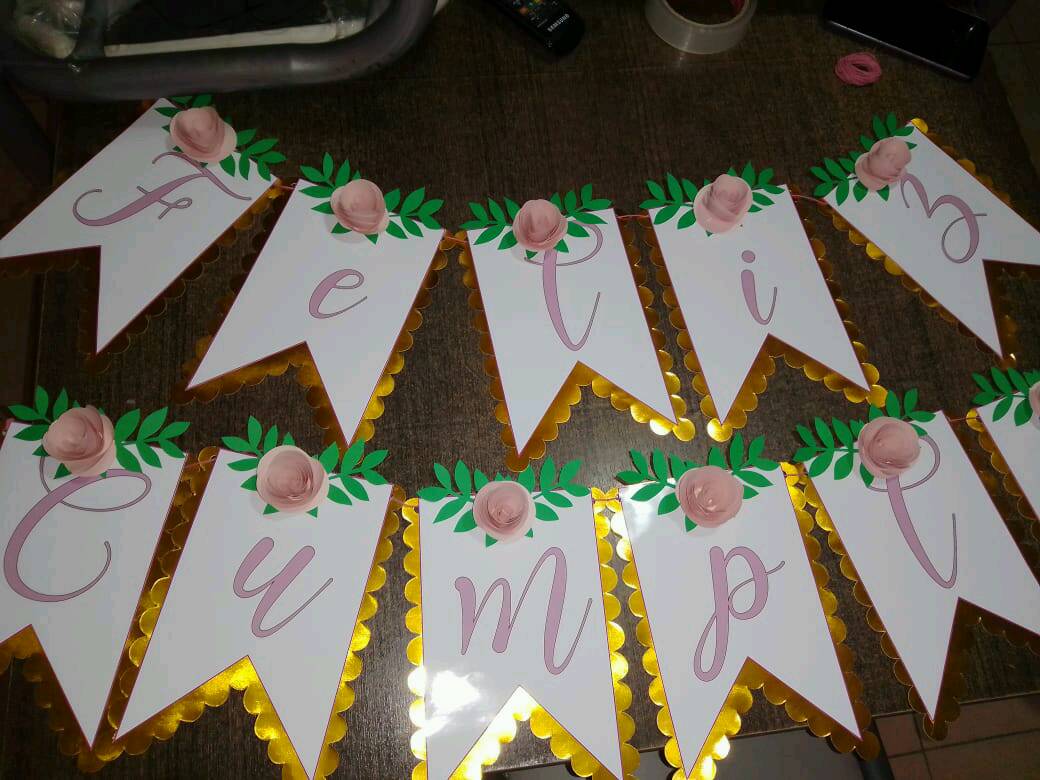 Banderín con letras en cartulinas y fondo dorado en Rosario